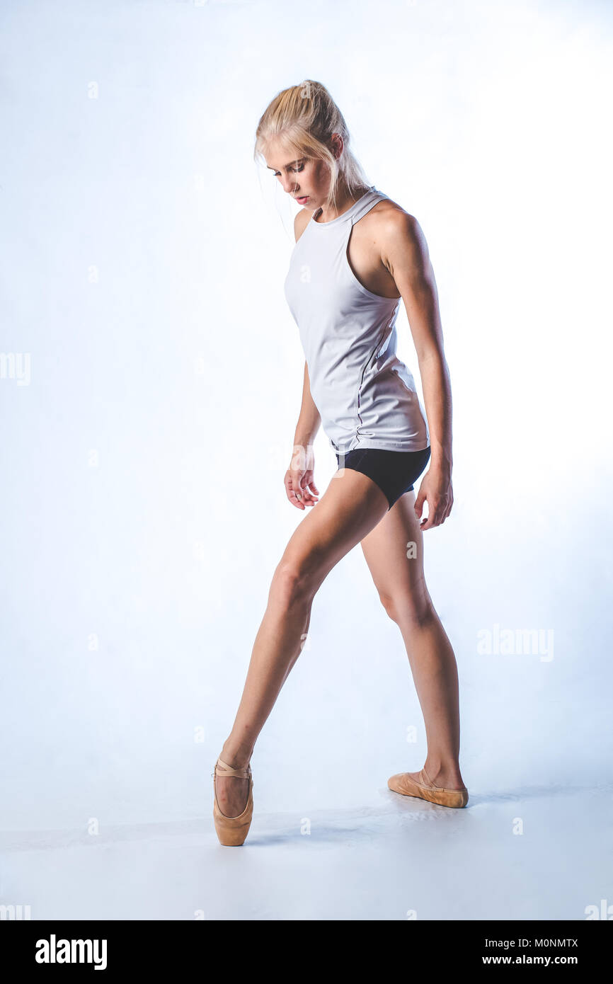 Beautiful female fitness model doing stretches and dancing in a studio ...