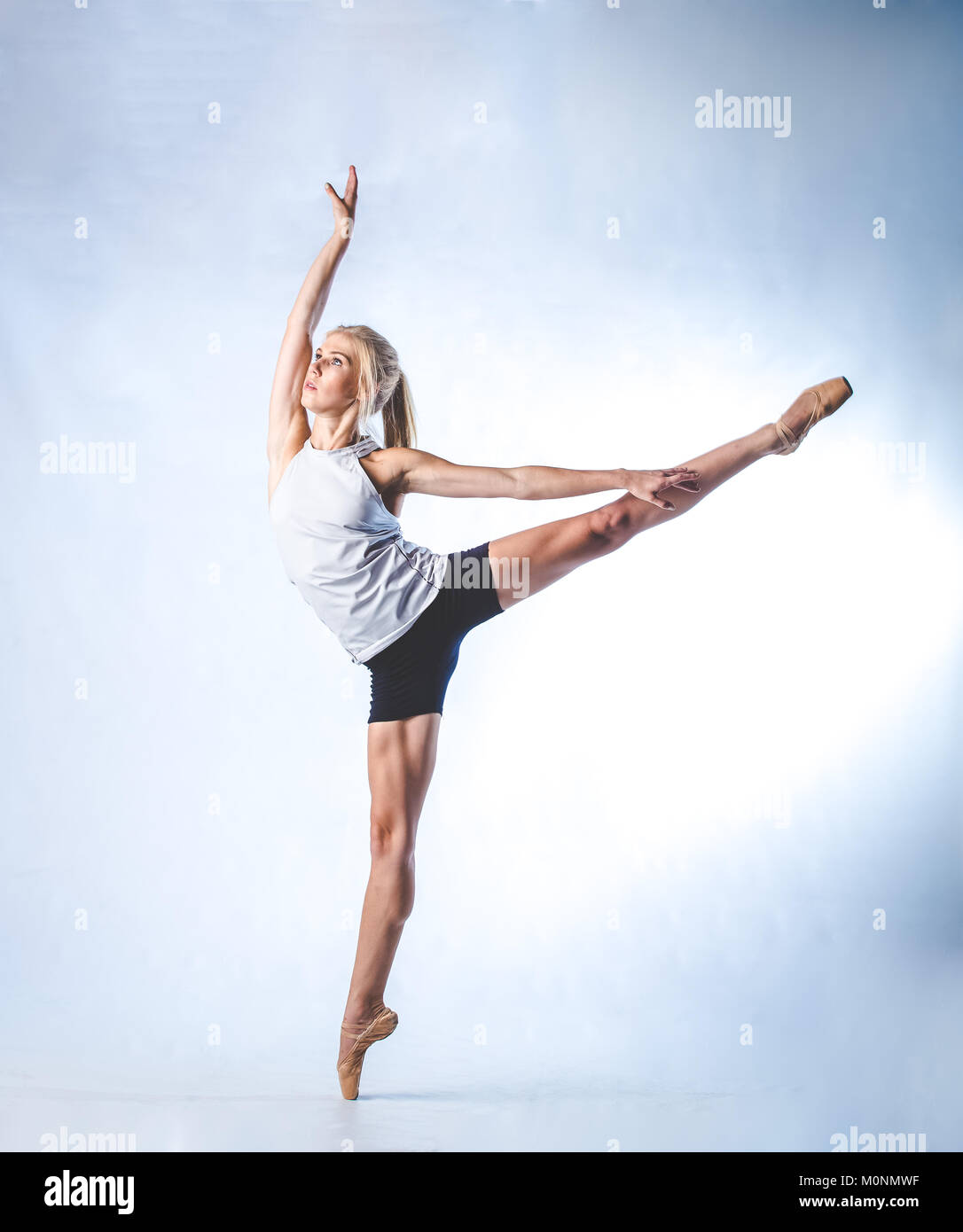 Beautiful female fitness model doing stretches and dancing in a studio ...
