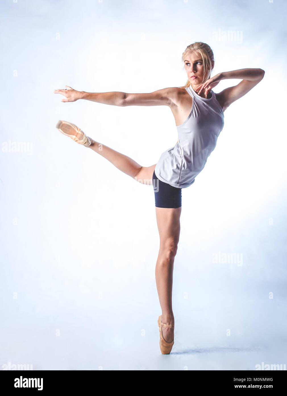 Beautiful female fitness model doing stretches and dancing in a studio ...