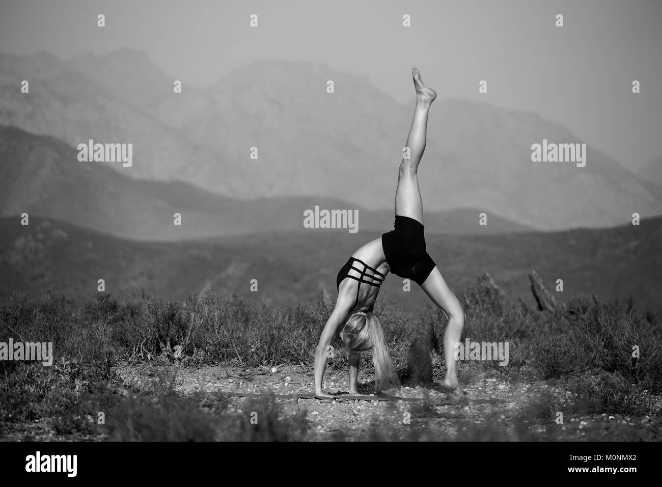 Female model practicing yoga in the outdoors doing stretching and ...