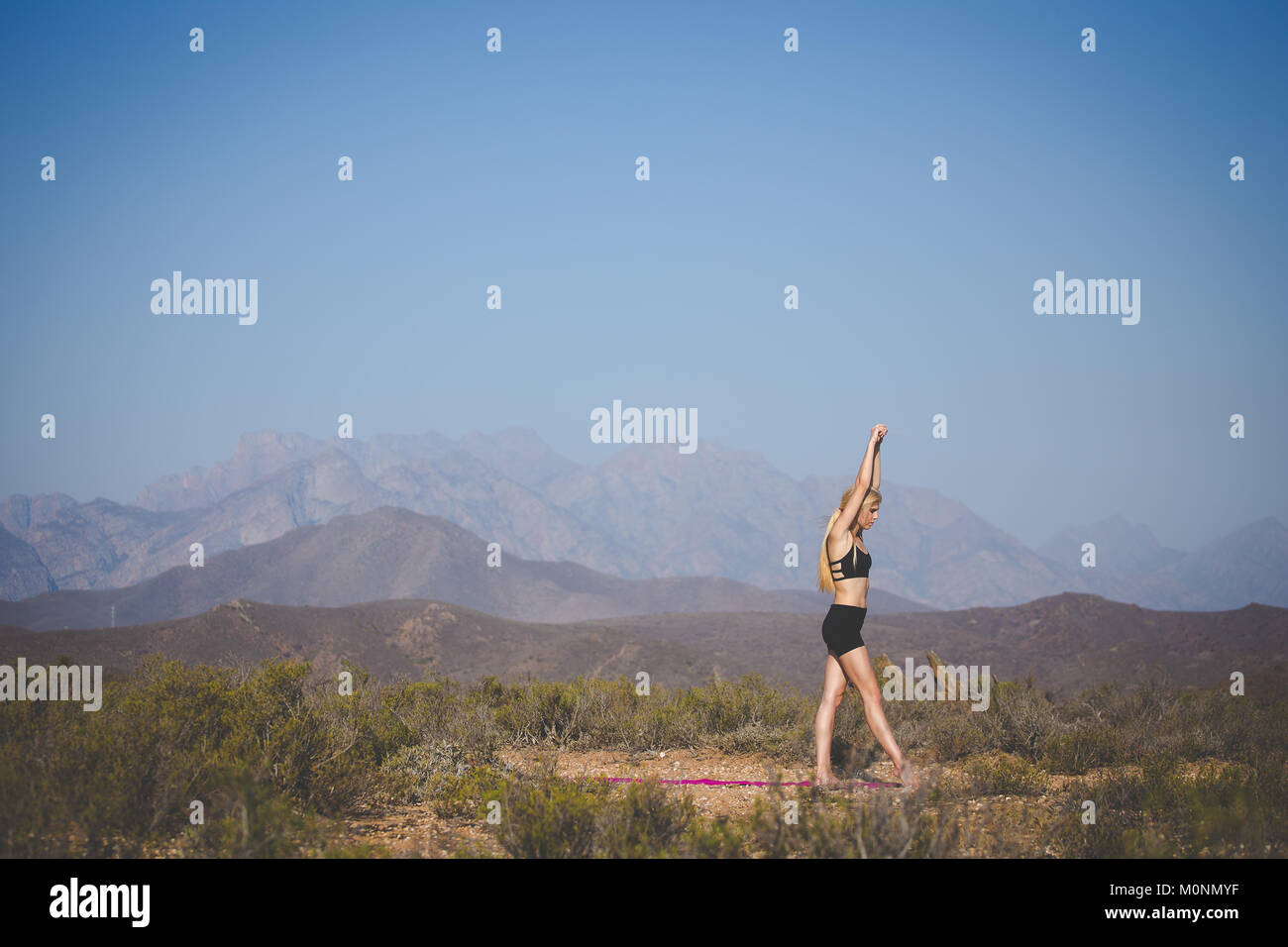 Female model practicing yoga in the outdoors doing stretching and ...
