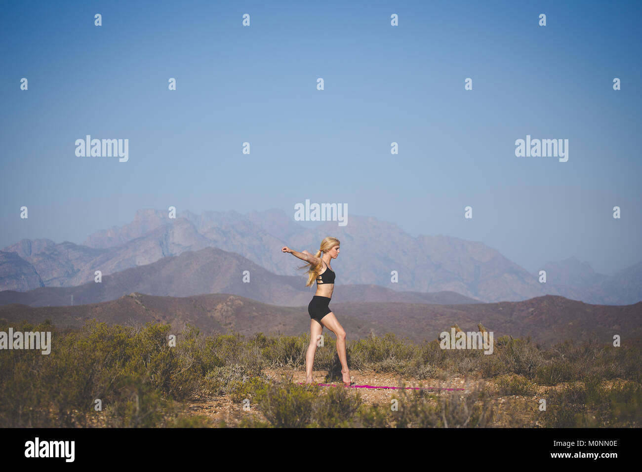 Female model practicing yoga in the outdoors doing stretching and ...