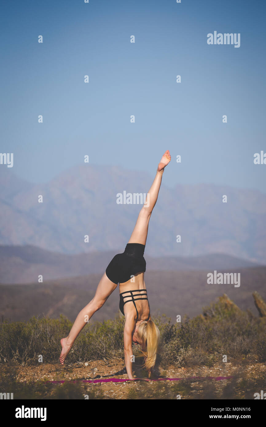 Female model practicing yoga in the outdoors doing stretching and ...