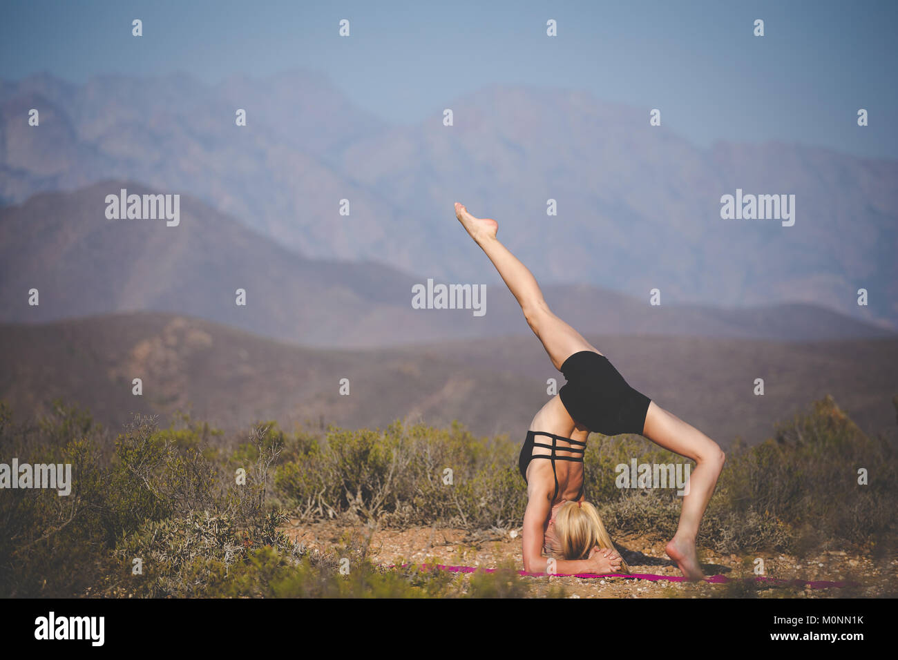 Female model practicing yoga in the outdoors doing stretching and ...