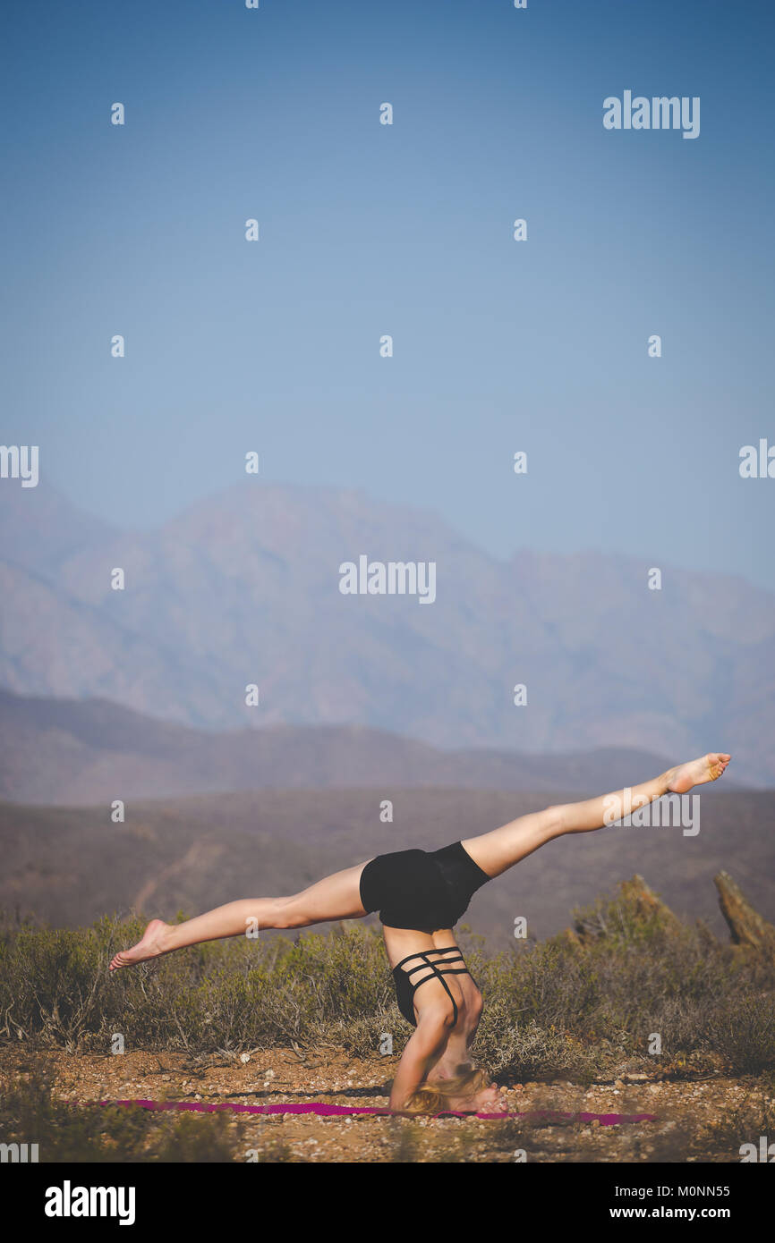 Female model practicing yoga in the outdoors doing stretching and ...