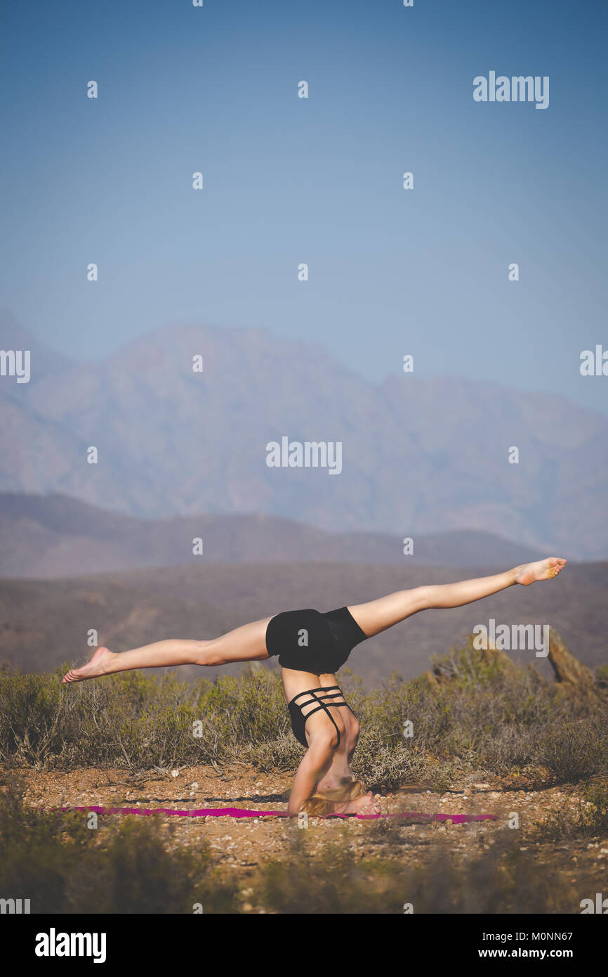 Female model practicing yoga in the outdoors doing stretching and ...
