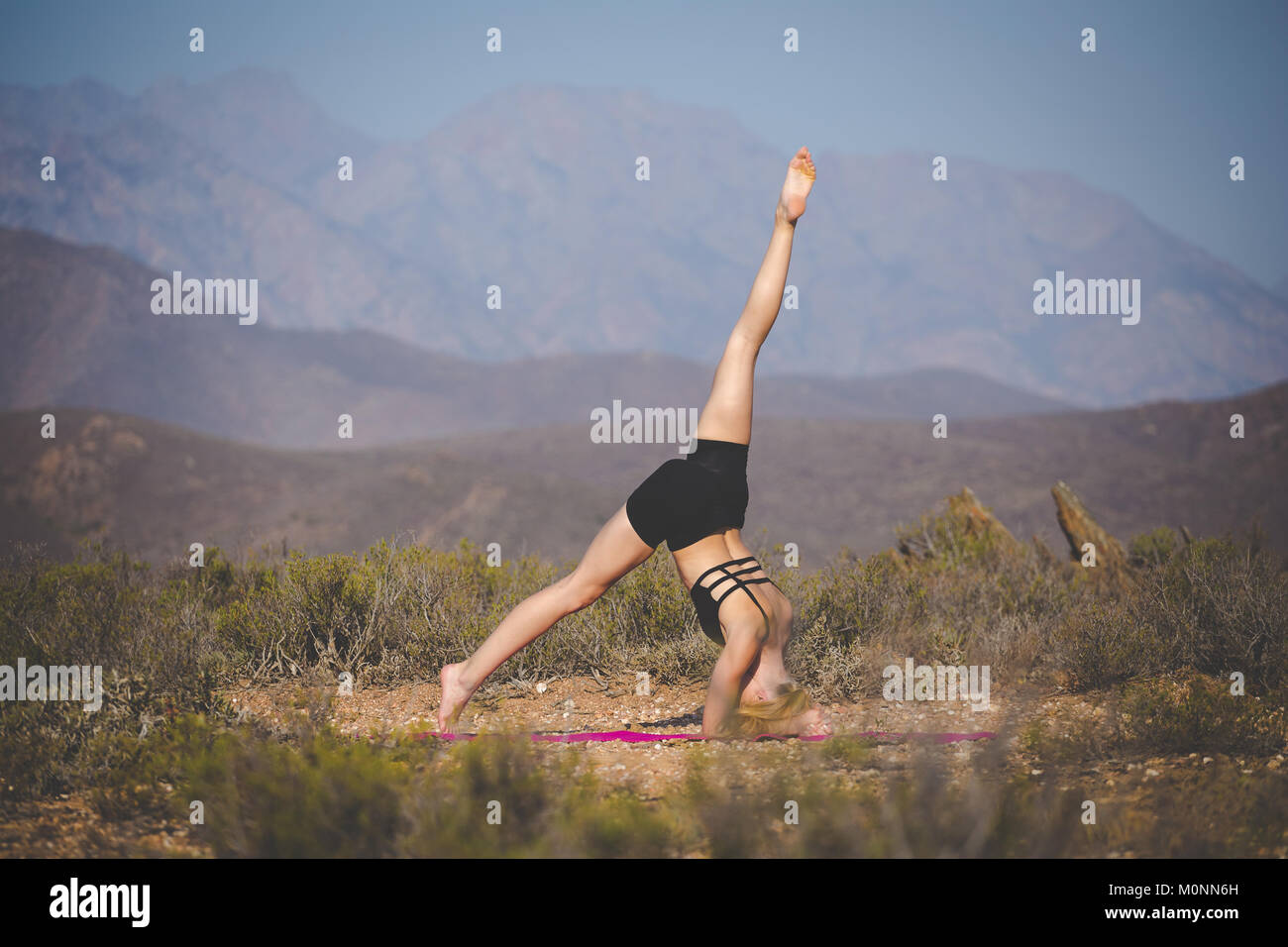 Female model practicing yoga in the outdoors doing stretching and ...
