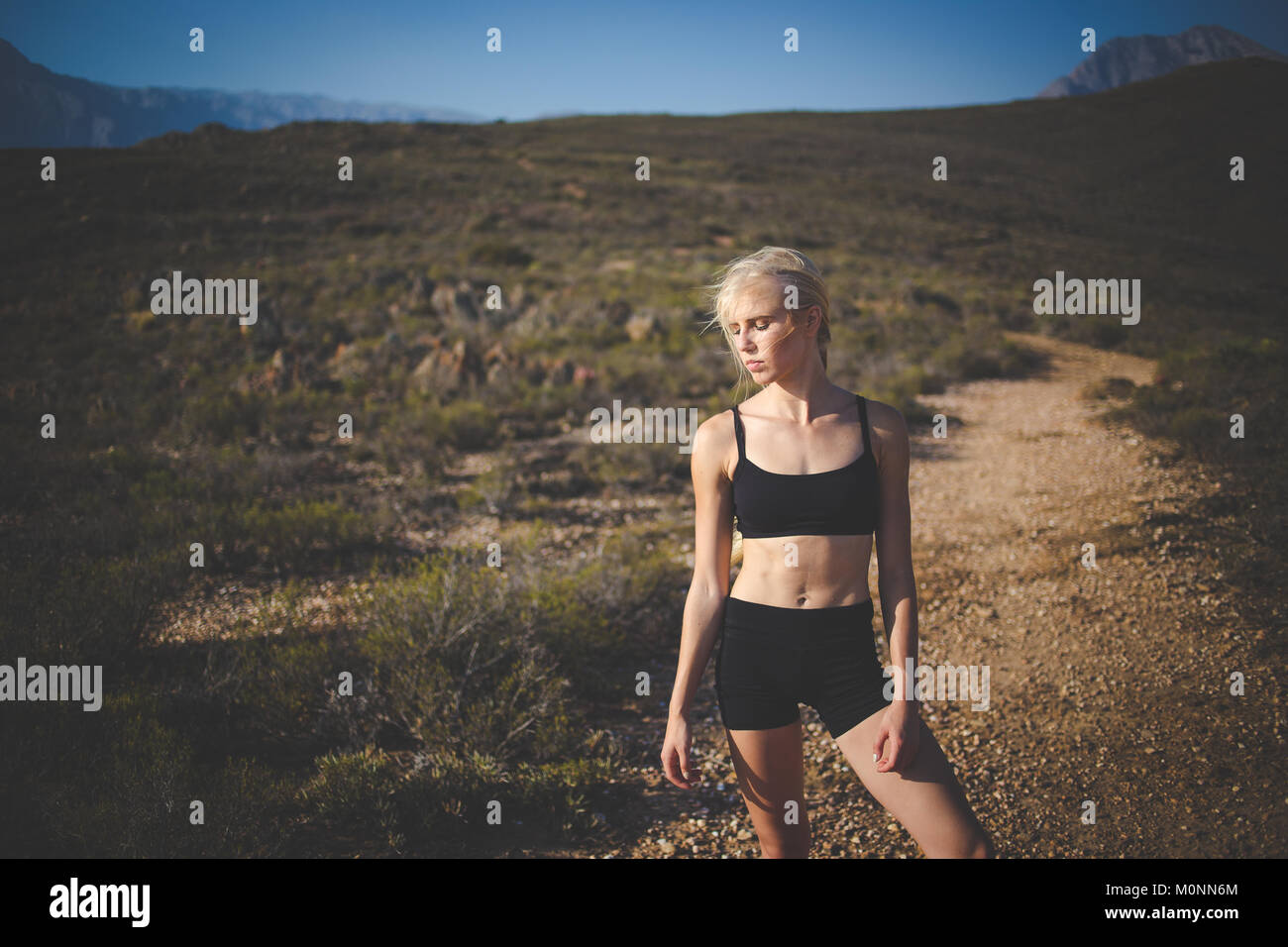 Female model practicing yoga in the outdoors doing stretching and ...
