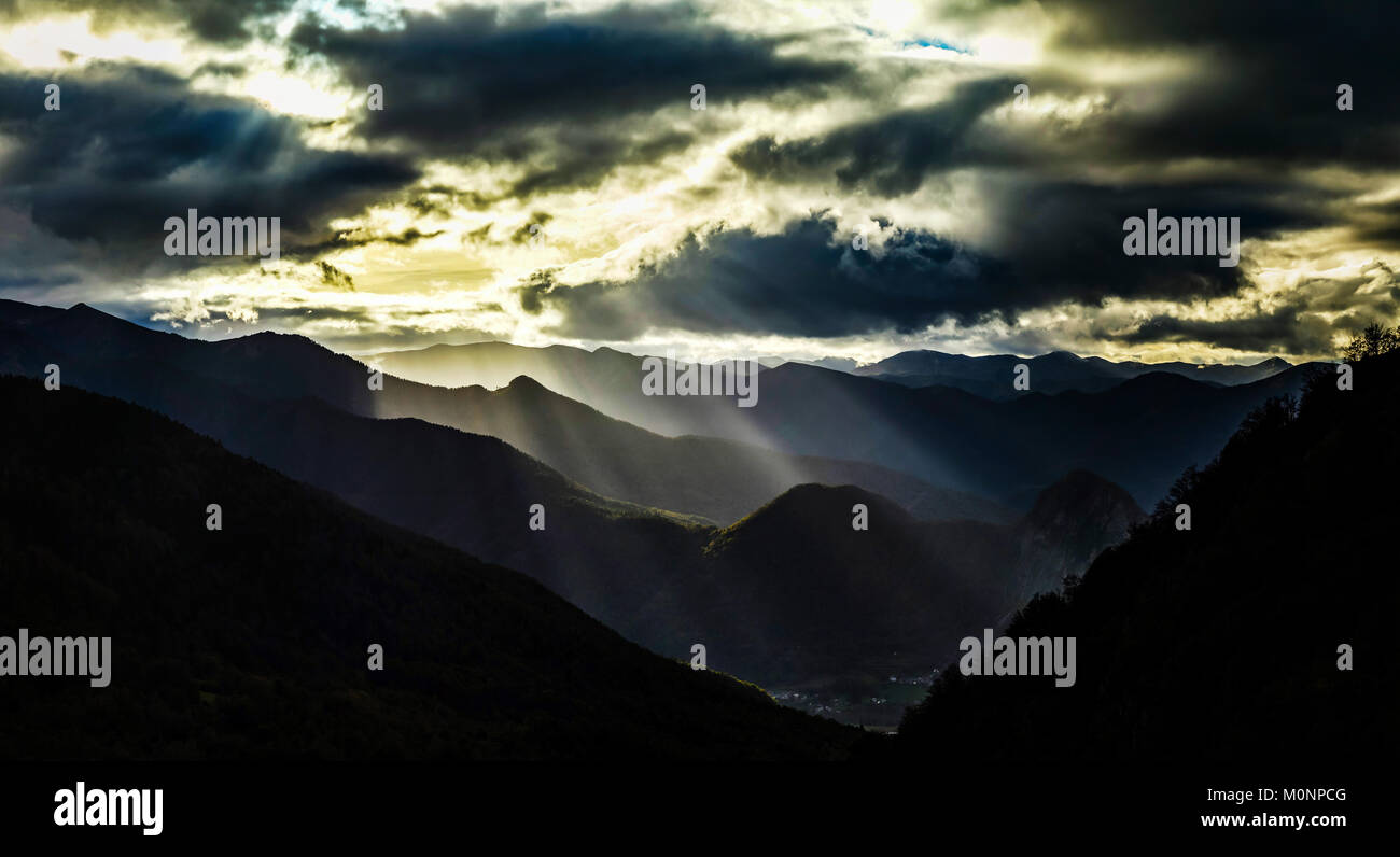 Sun rays lighting through the clouds in high Pyrenees, sunrise, green ...