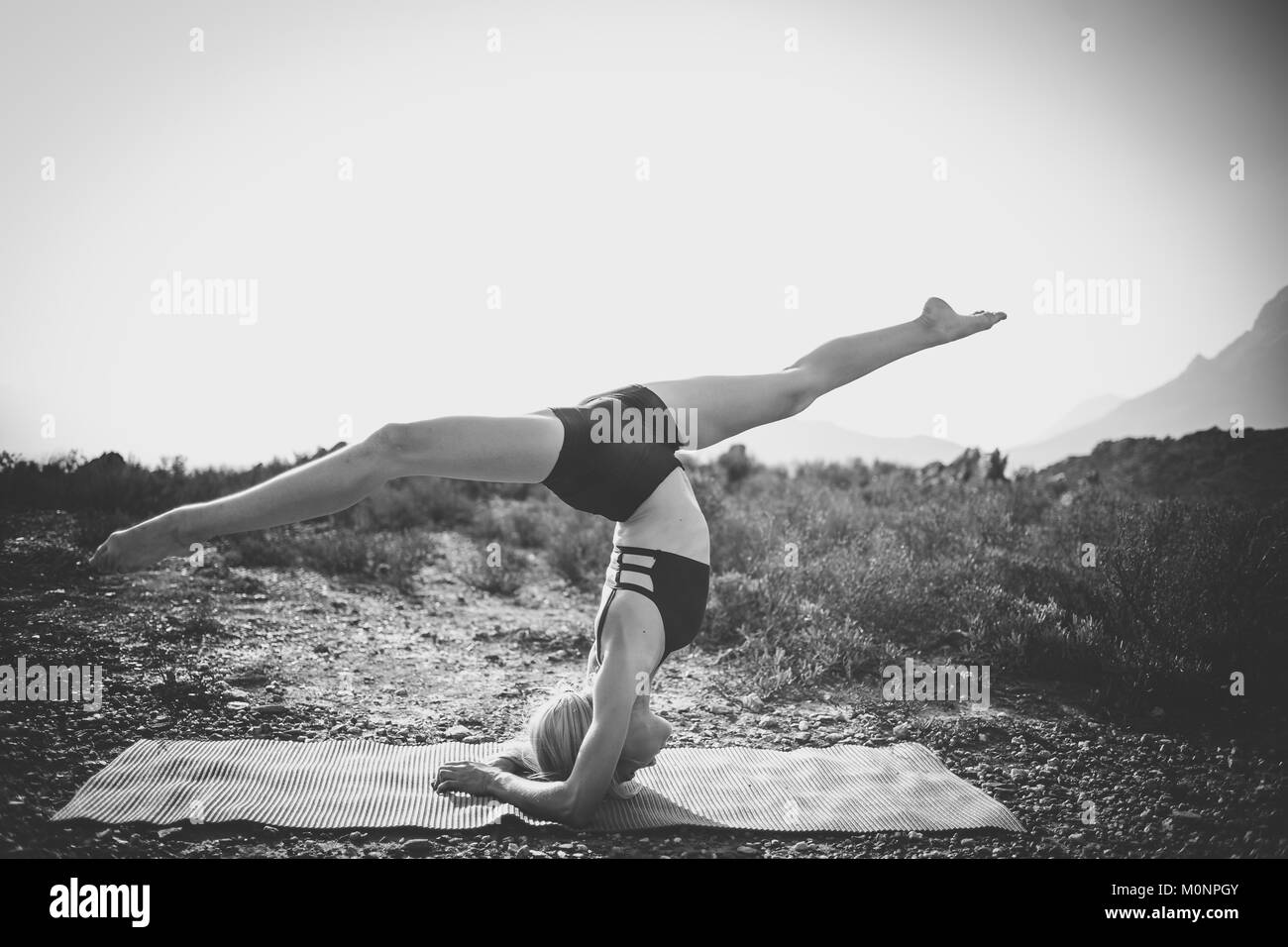 Female model practicing yoga in the outdoors doing stretching and ...