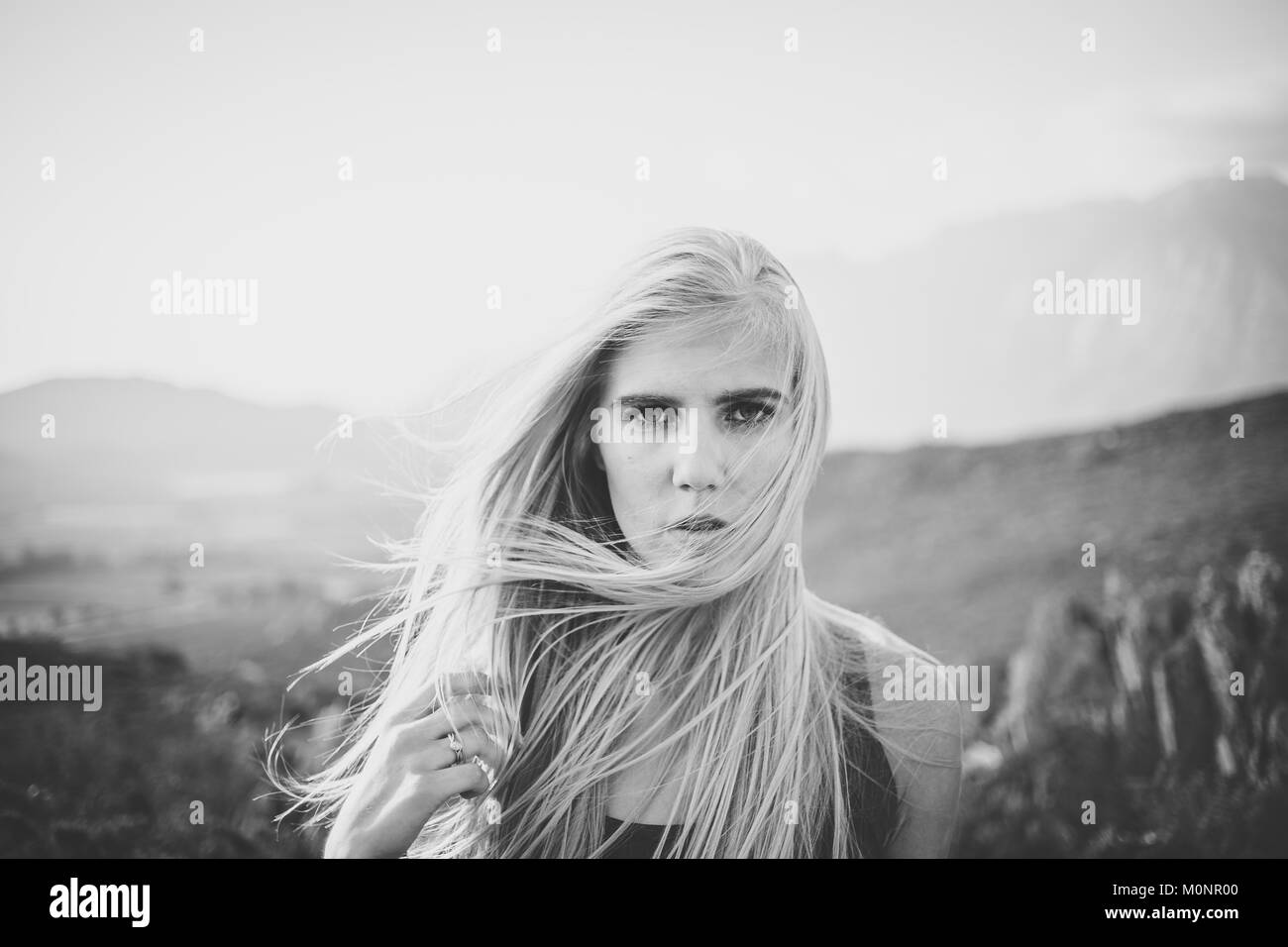 Portrait of a beautiful blond female model in a natural setting with ...