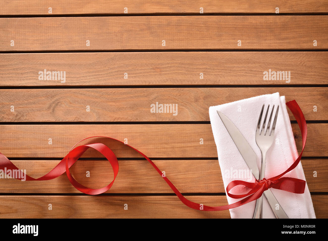 Table decorated with red ribbon for special event and planked wood ...