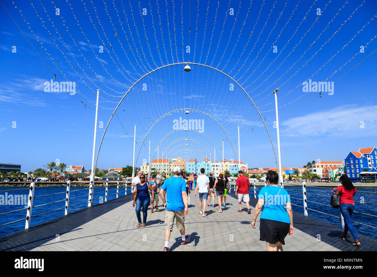 Tourists walking across movable pontoon bridge in Curacao Stock Photo ...