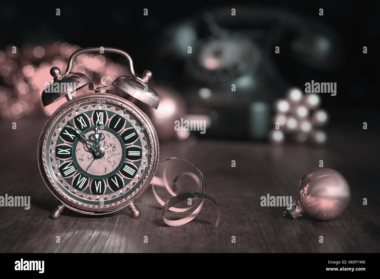 Composition with vintage alarm clock showing five to midnight and an ...