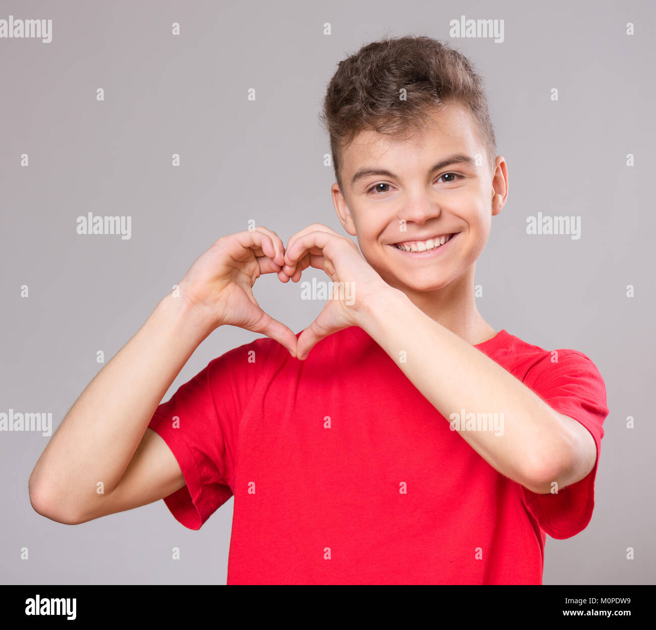 Portrait of happy teenager with a heart shape, isolated on white ...