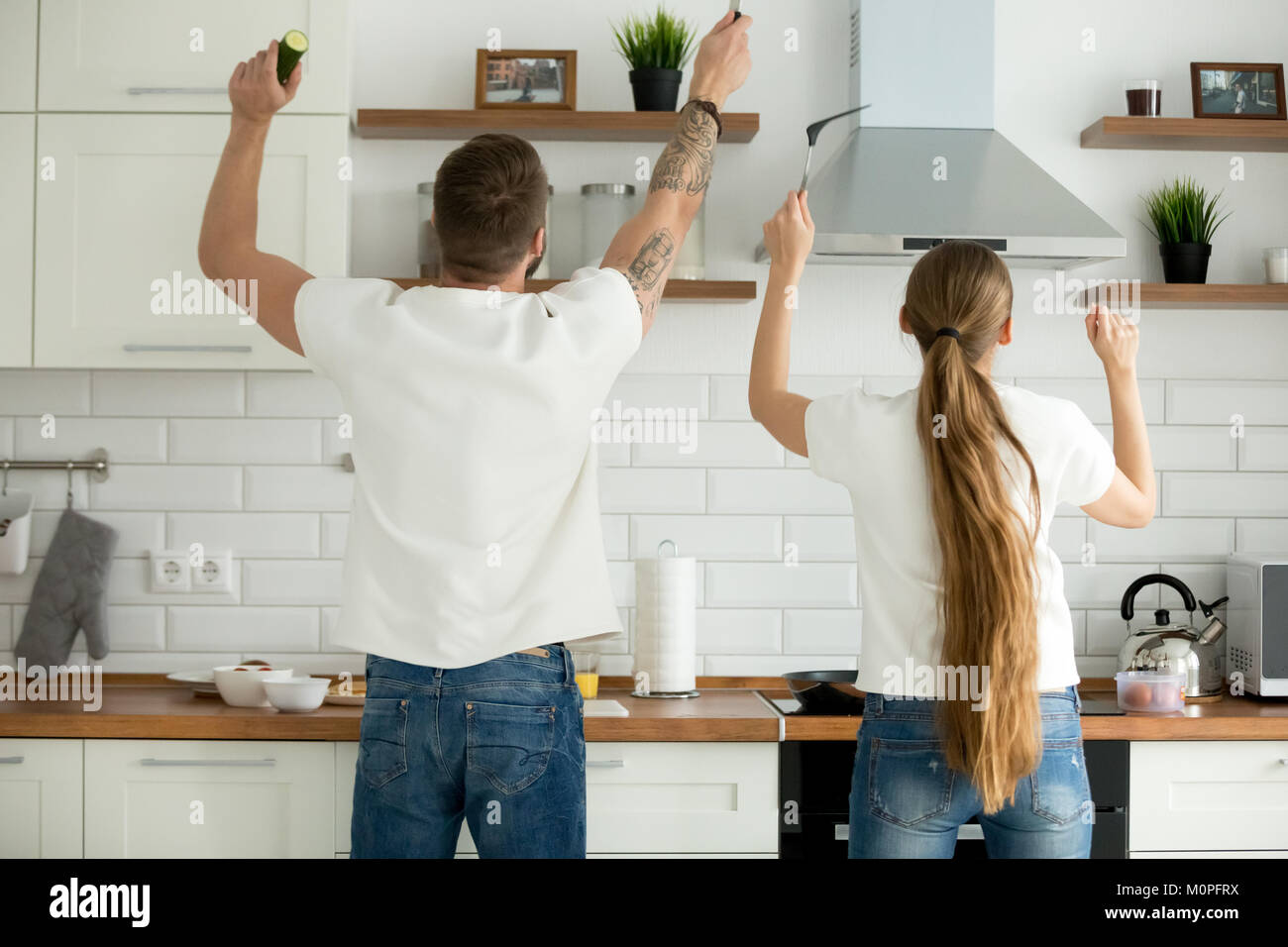 Rear view at couple cooking breakfast together in the kitchen Stock ...