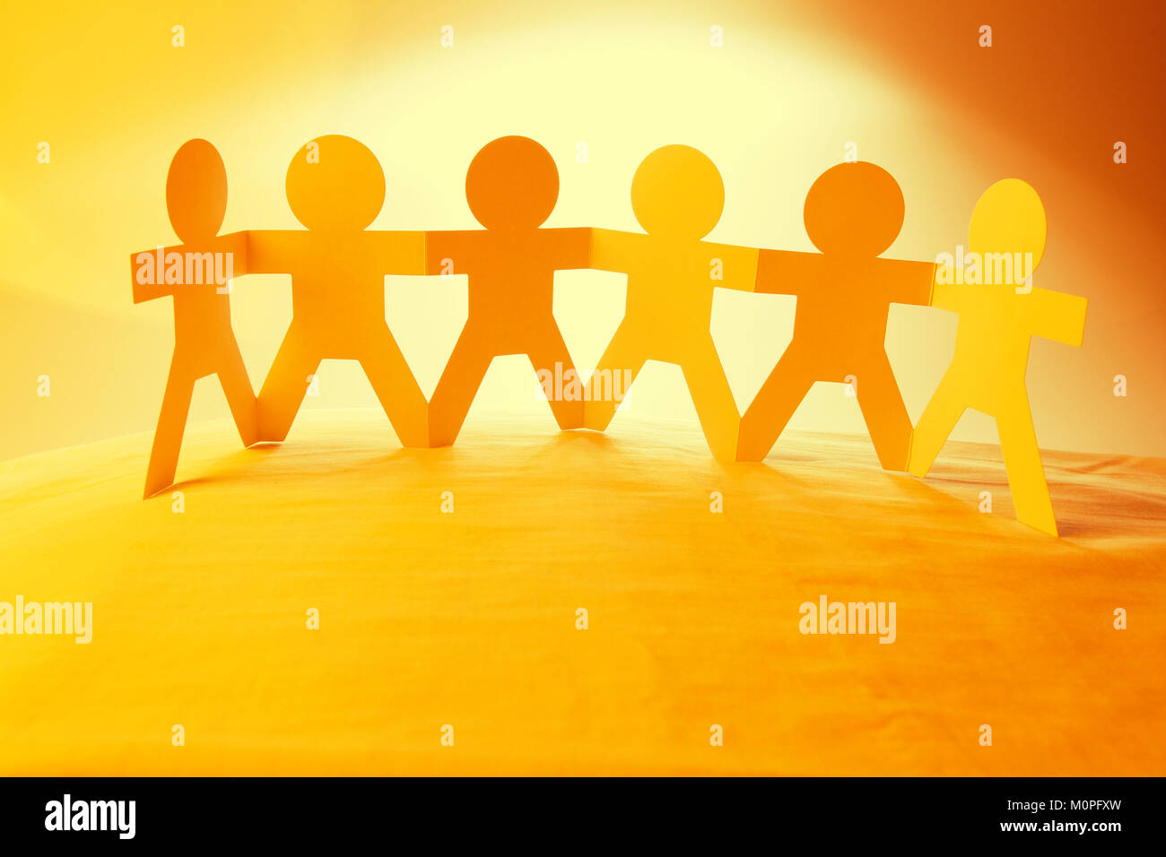 Team of paper chain people in a row holding hands Stock Photo - Alamy