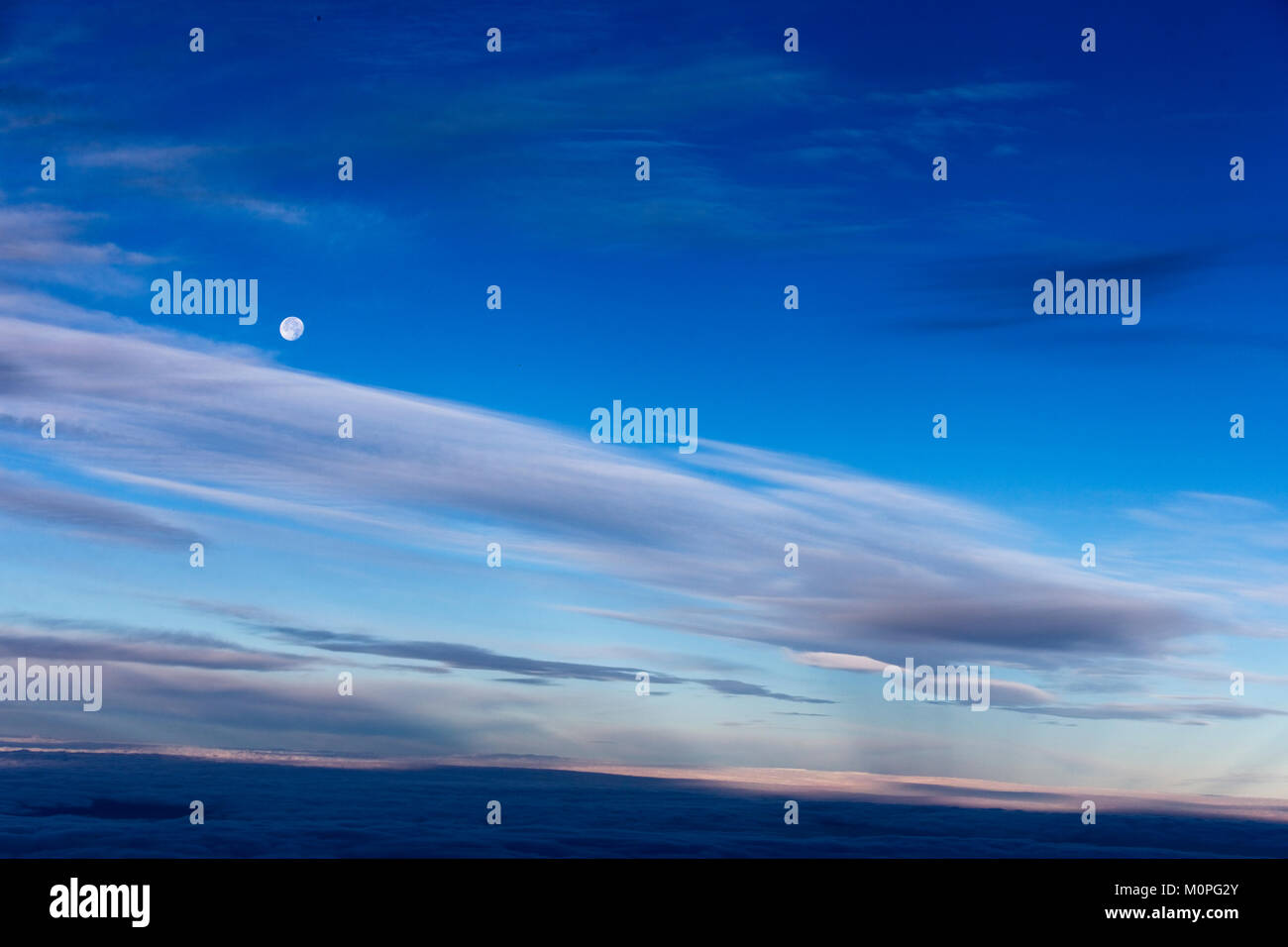 Skyscape, in-flight shot of the early morning sky with the Moon Stock ...