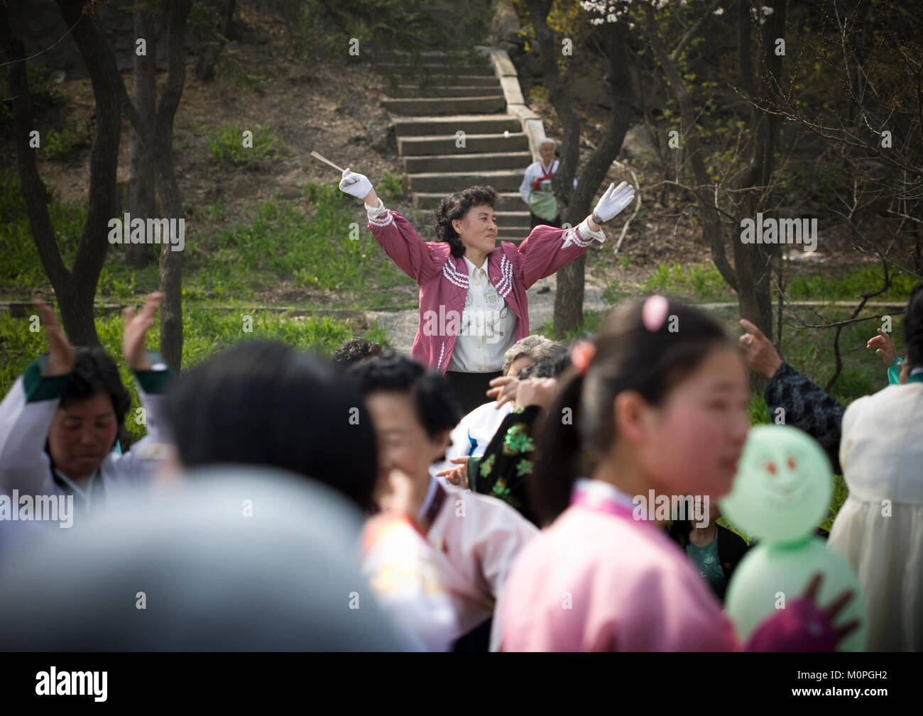 North Korean people dancing in a park for the day of the sun which is ...