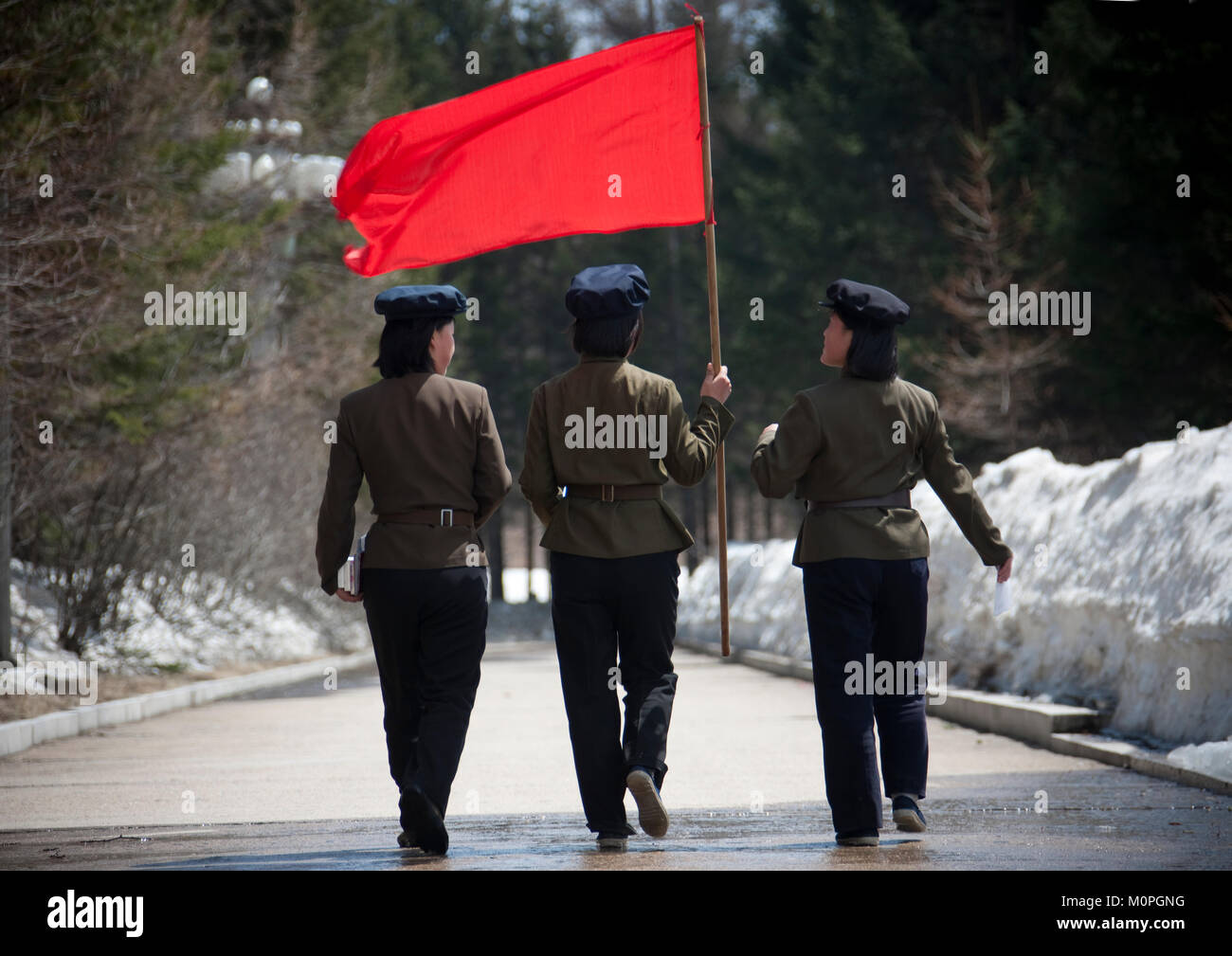 North Korean students with a red flag walking on the steps of the ...