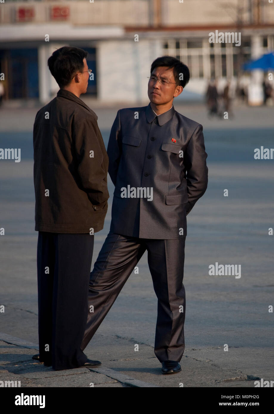 North Korean men dressing with vinylon suits chatting in the street ...