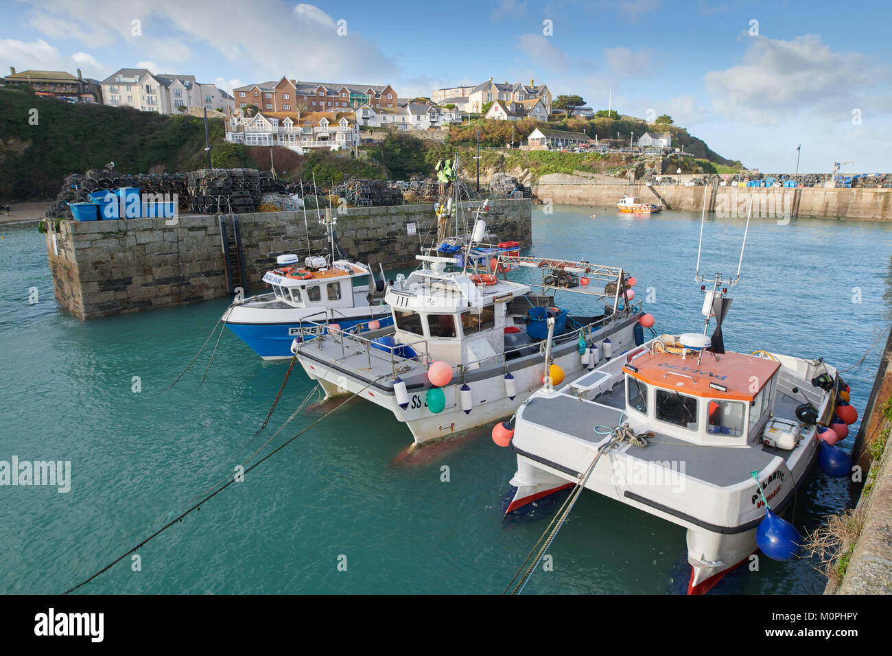 Three fishing boats moored against newquays harbour wall at high tide ...