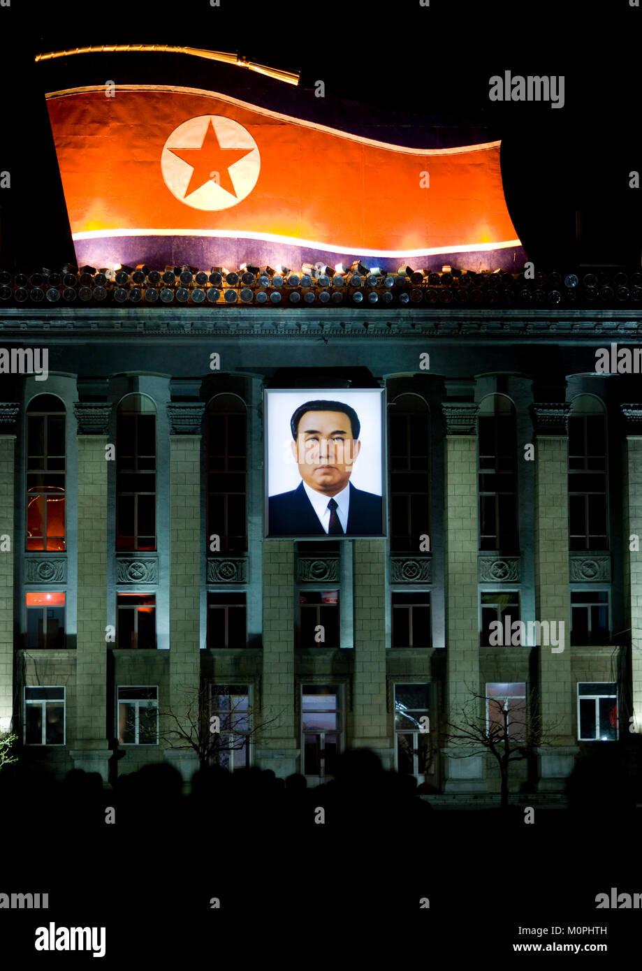 Kim il Sung square at night with a North Korean flag and a portrait of ...