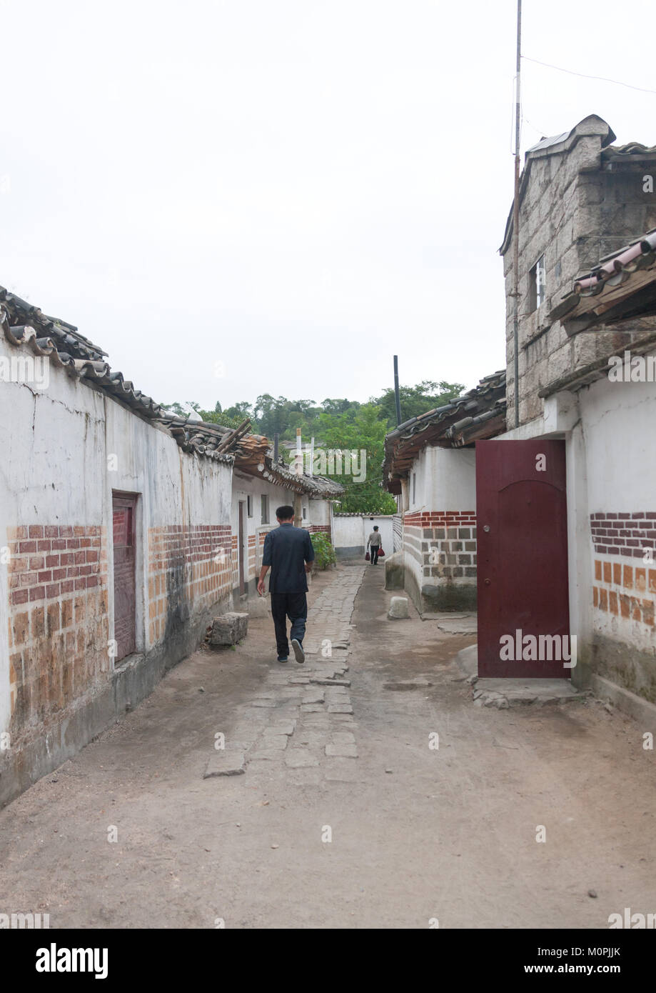 North Korean man passing through a street of the old town, North ...