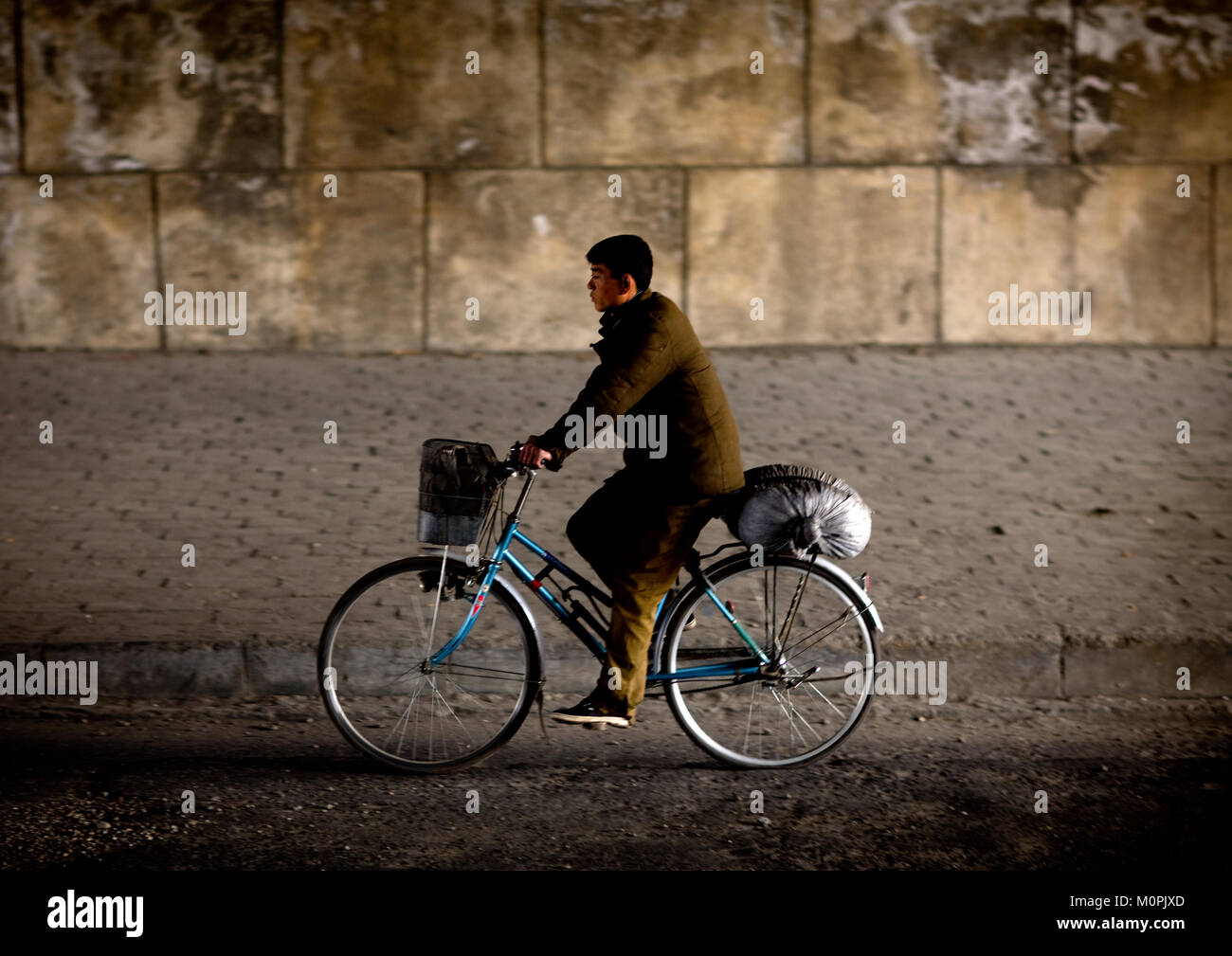 North Korean man riding a bicycle in a tunnel, Pyongan Province ...