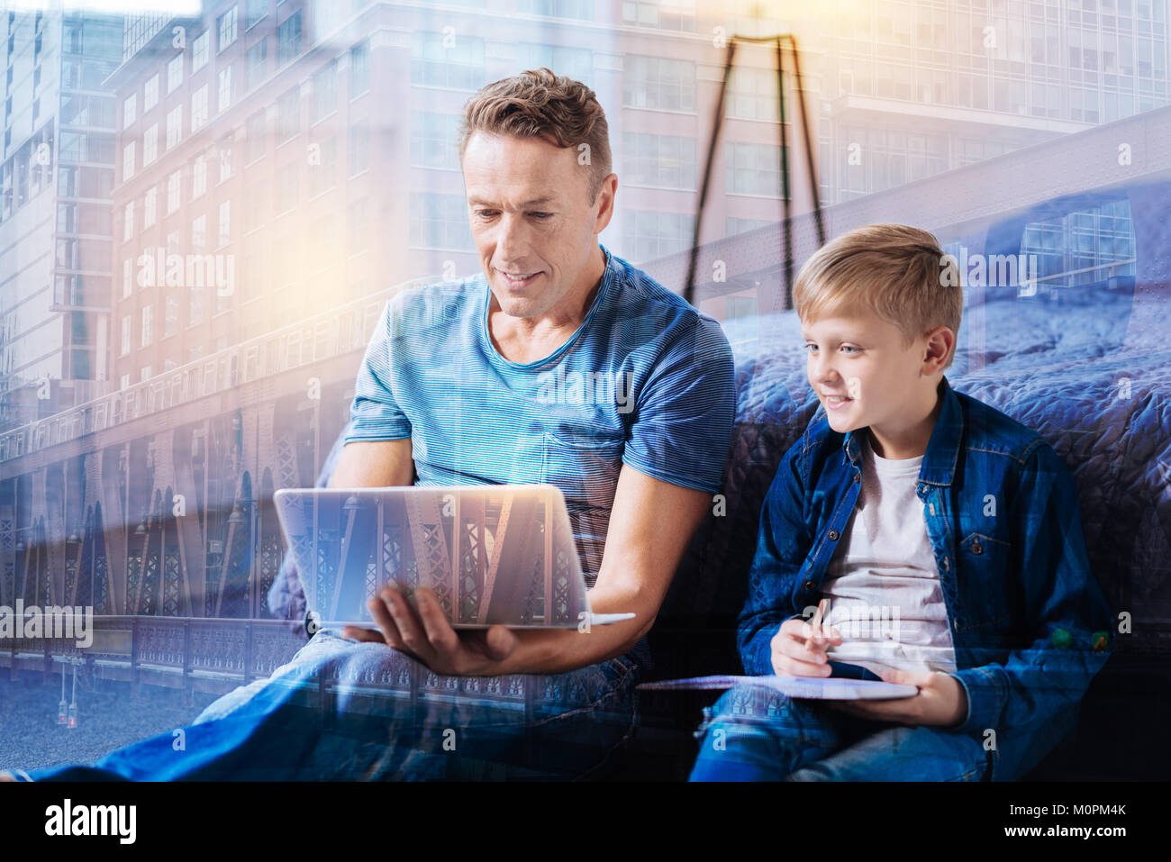 Attentive man sitting near his son Stock Photo - Alamy