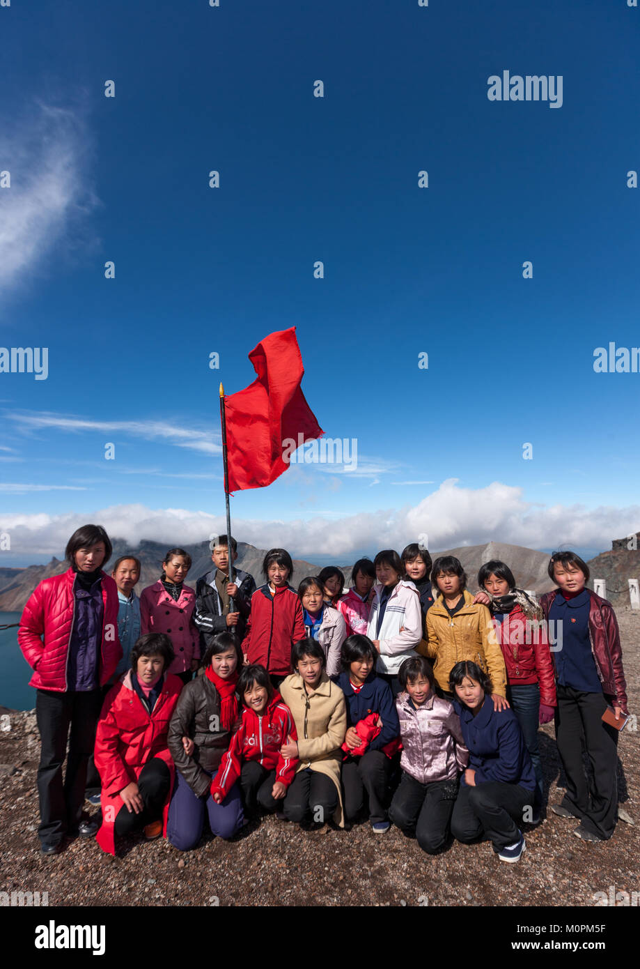 Group of students with red flag in front of lake at mount Paektu ...