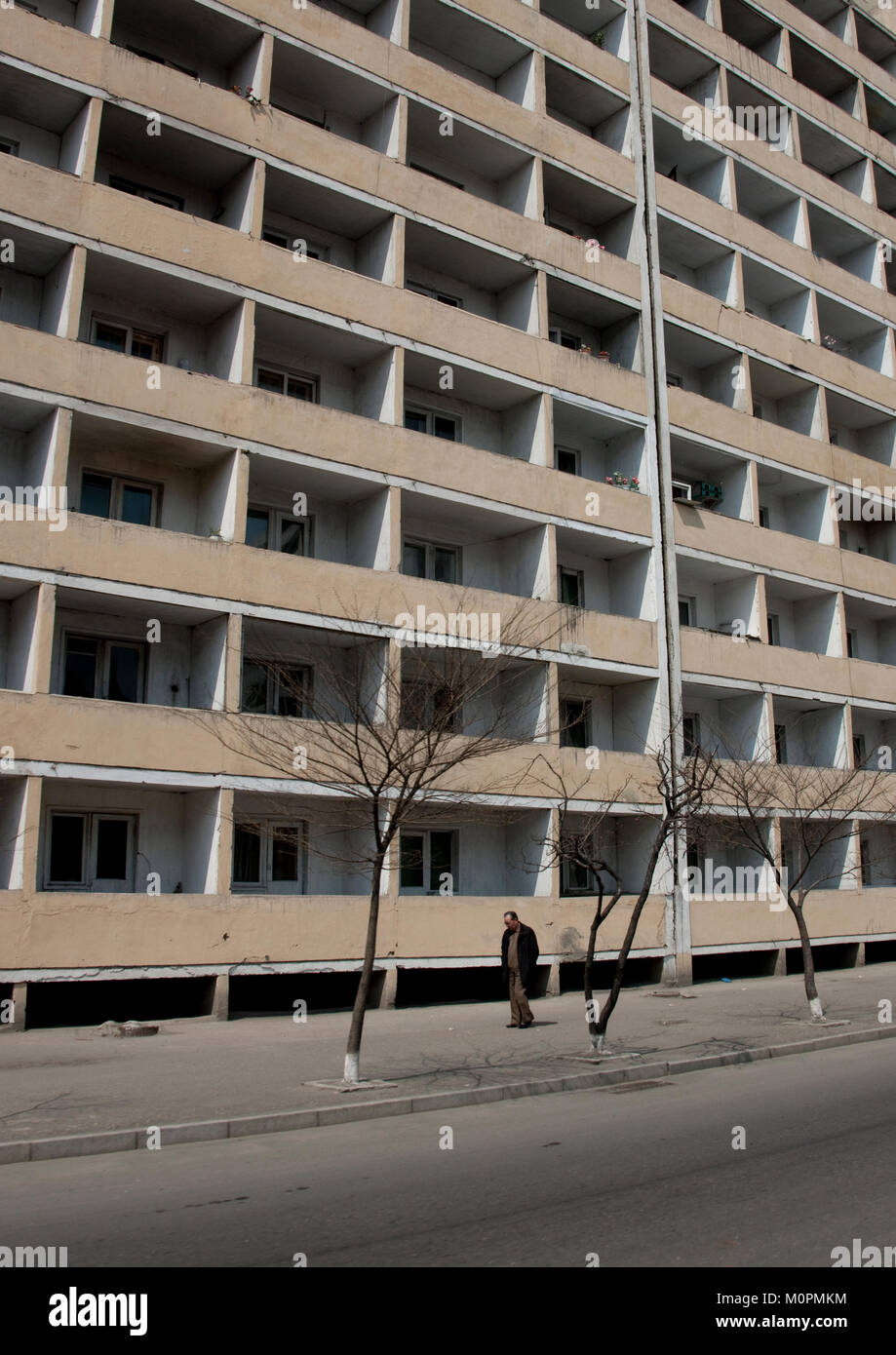 North Korean man walking in the street in front a building, Pyongan ...