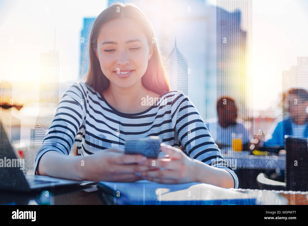 Positive girl with a mobile phone in hands Stock Photo - Alamy