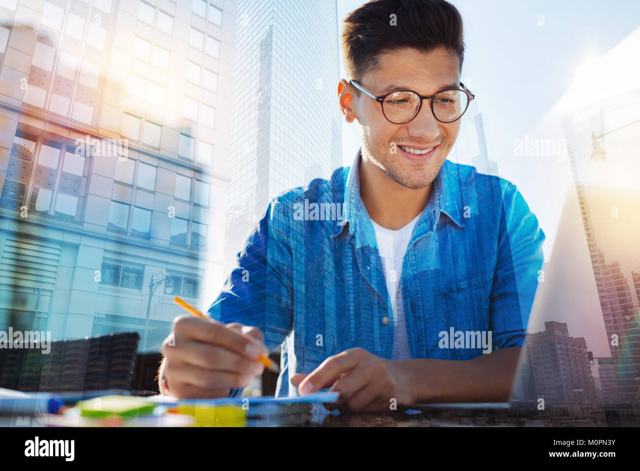 Cheerful young man holding a pencil Stock Photo - Alamy
