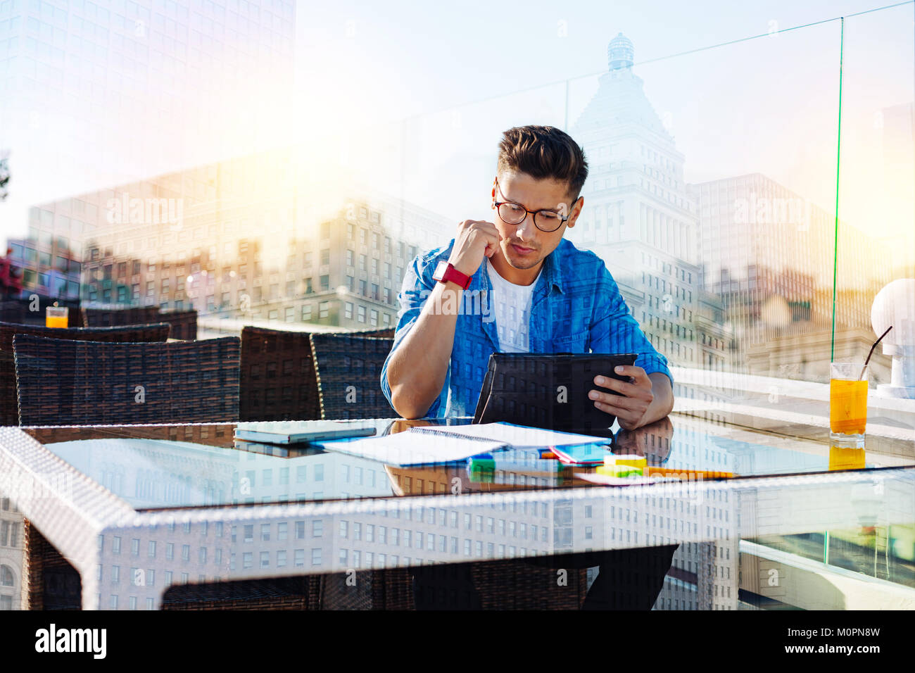 Concentrated man reading information on a tablet Stock Photo - Alamy