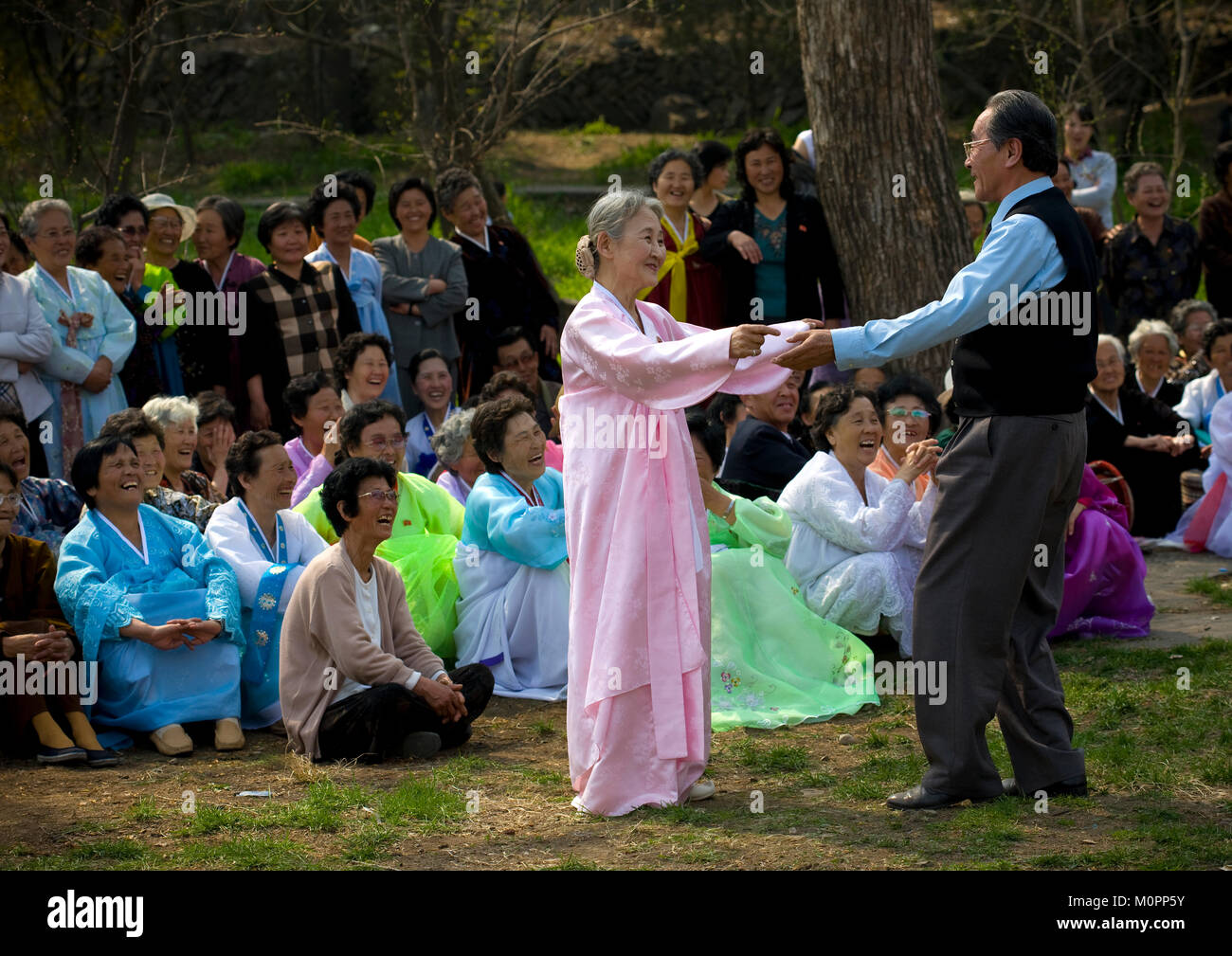North Korean people dancing in a park for the day of the sun which is ...