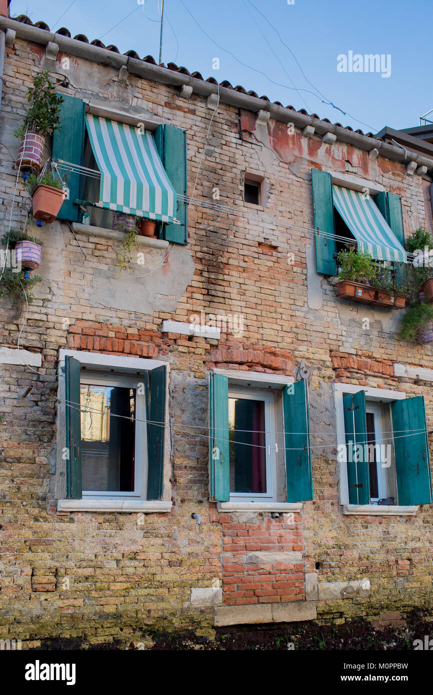 Brick building in Venice neighborhood with green shutters and striped ...