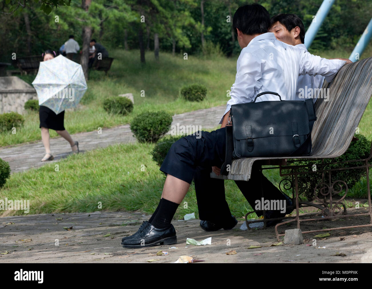 North Korean men resting on a bench in a park, Pyongan Province ...