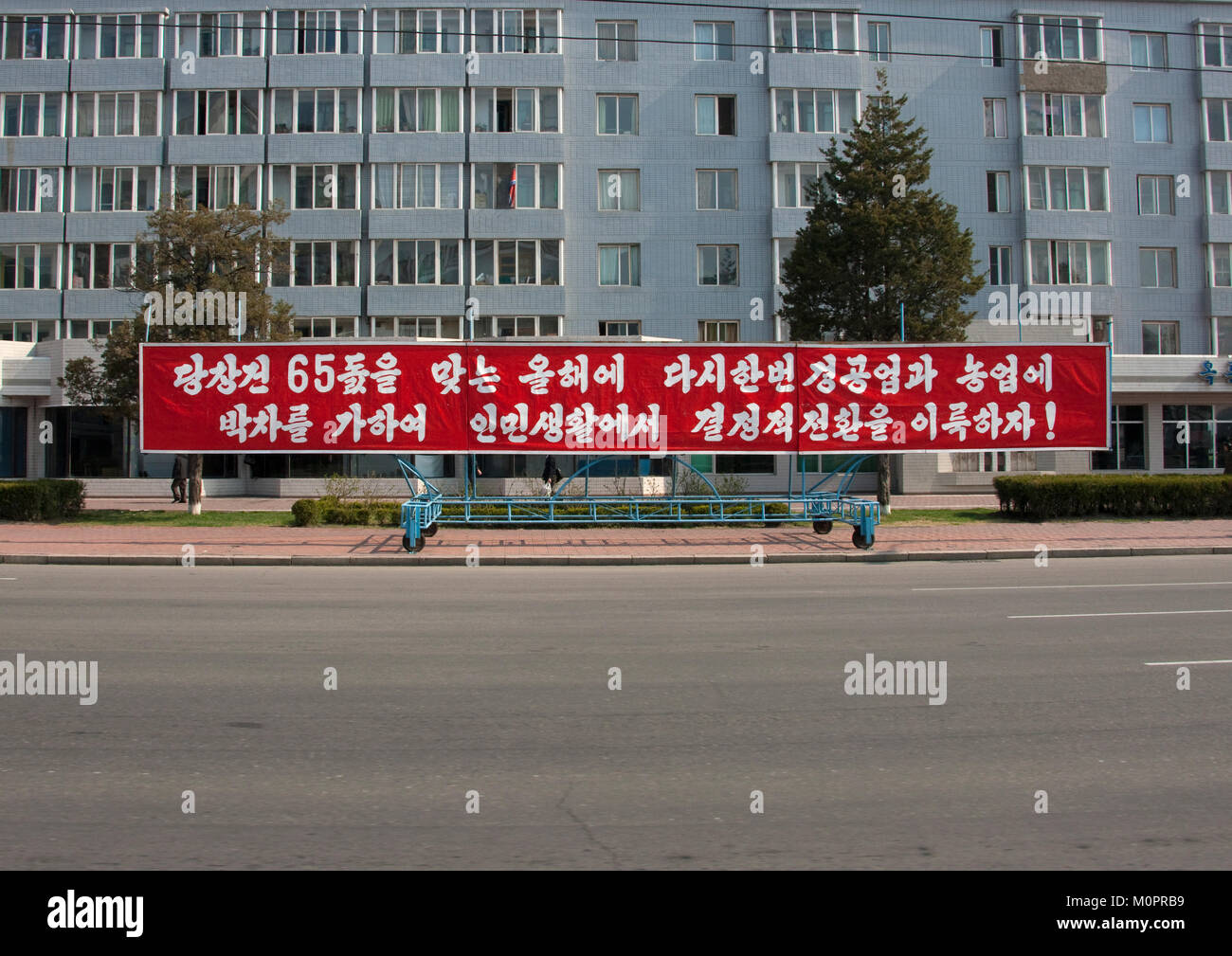 Propaganda slogan about industry and agriculture on a red billboard in ...