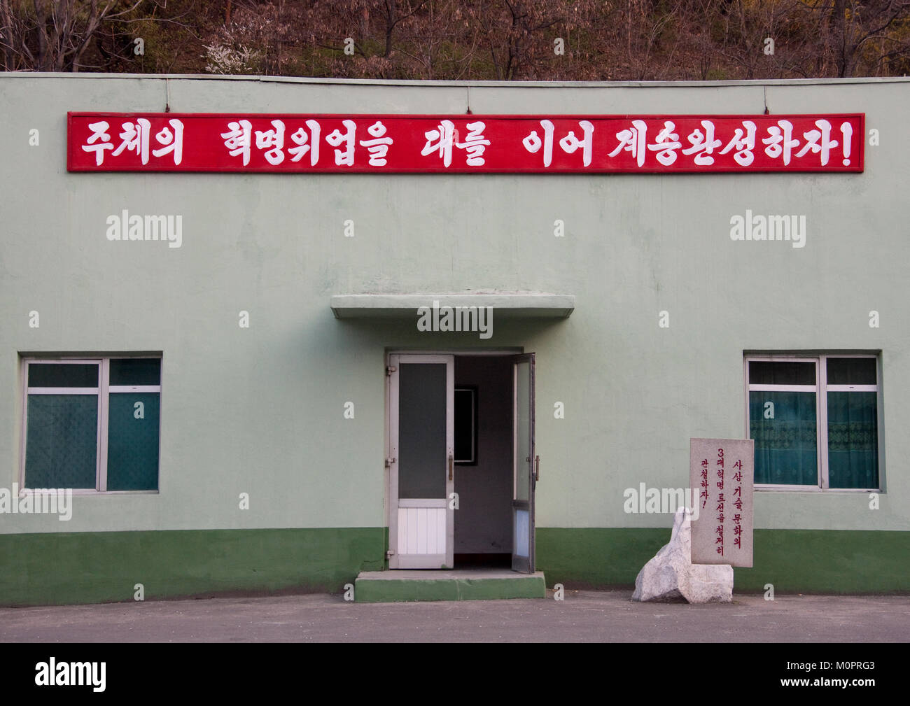 Propaganda slogan above the entrance of a building saying let us ...
