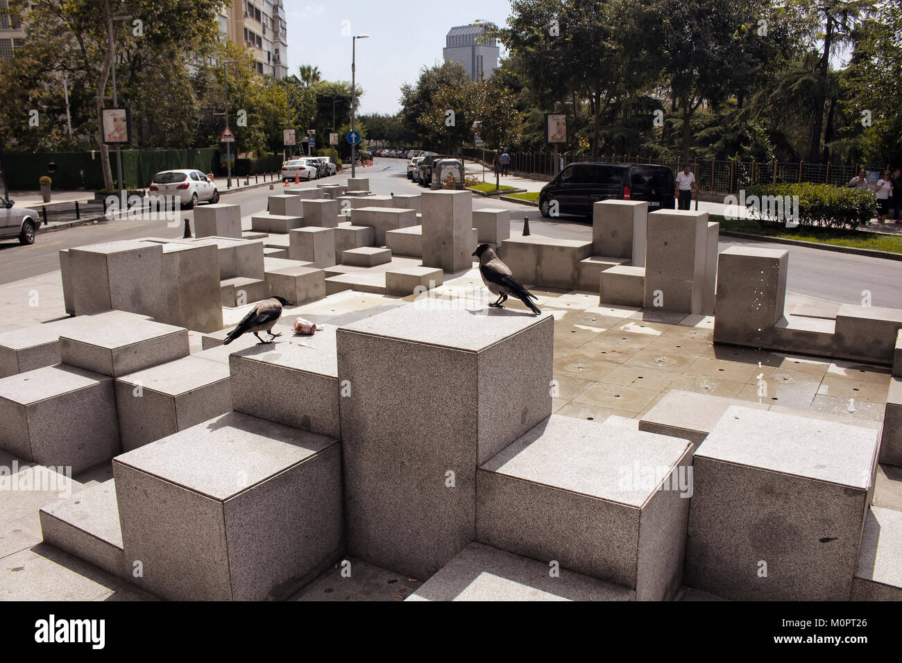 View of modern fountain made with concrete blocks. Two crows on it ...