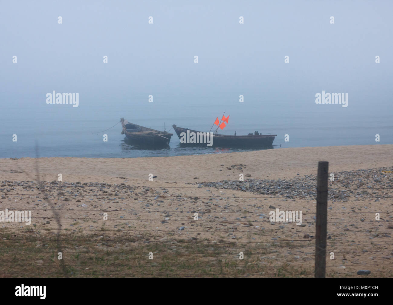 Boats on a beach in the mist, Kangwon Province, Wonsan, North Korea ...