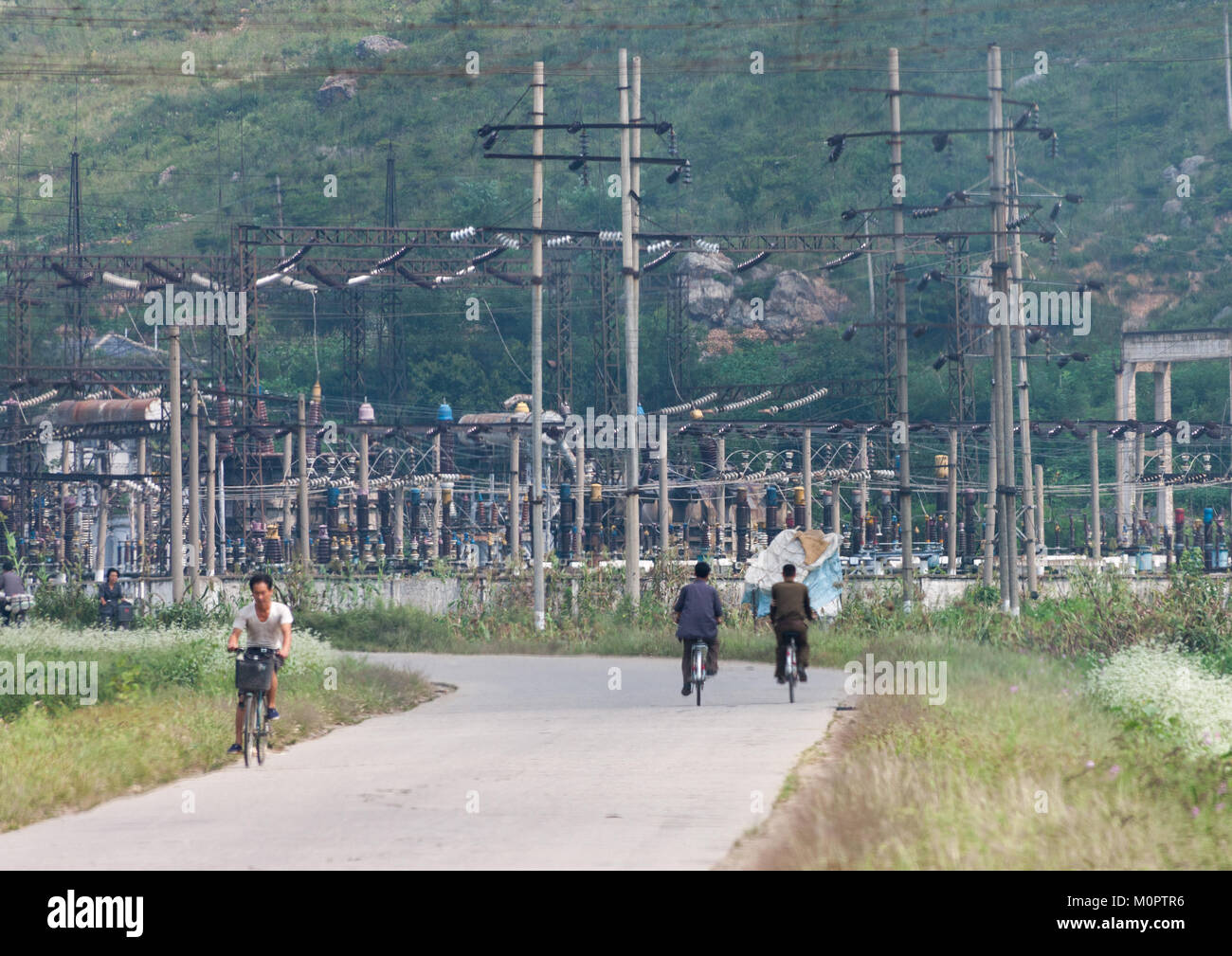 North Korean men riding in font of a power station, North Hwanghae ...