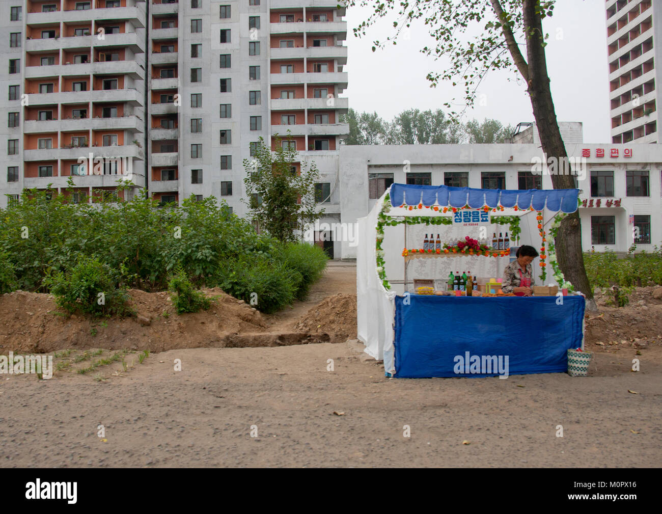 Food stall with no customers in front of apartment blocks, Pyongan ...