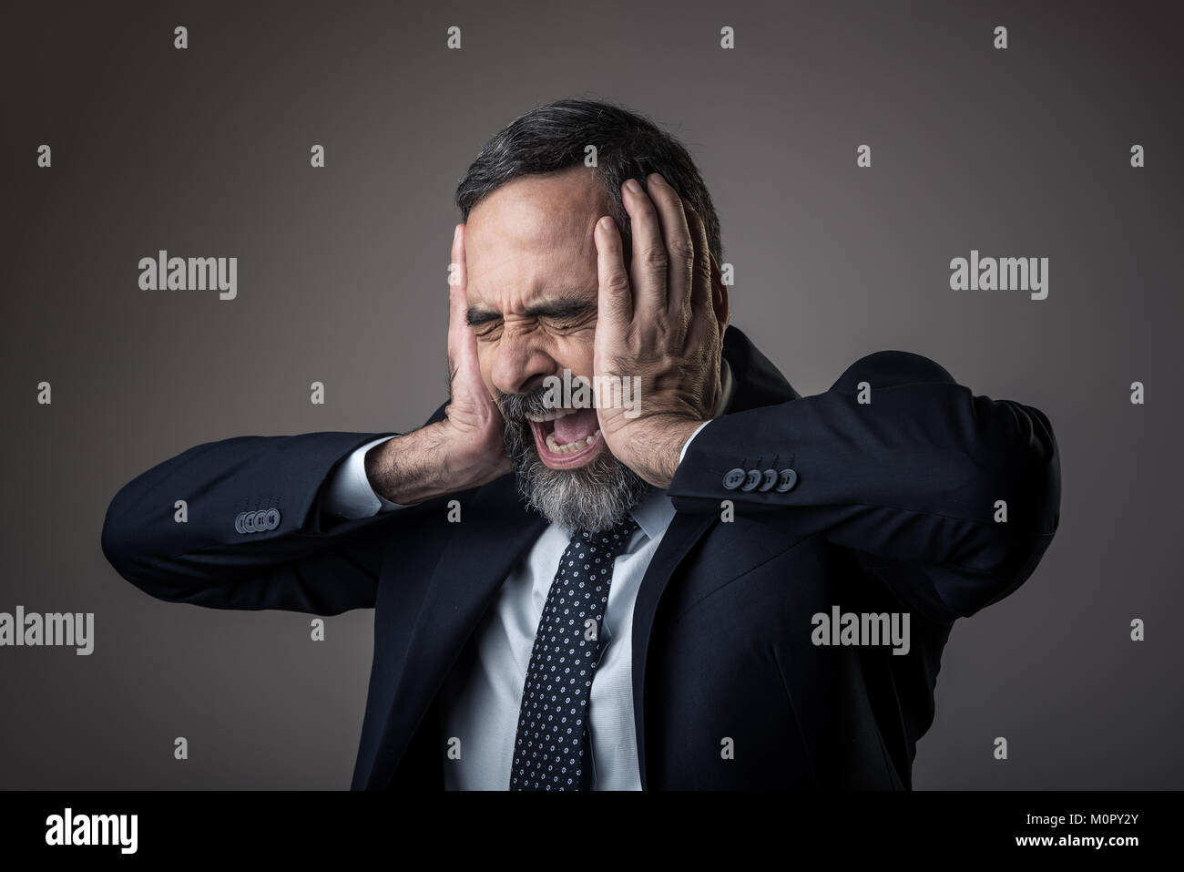 Angry business man with a terrible headache Stock Photo - Alamy