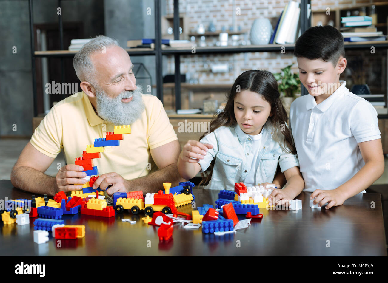 Joyful family playing with building block at home Stock Photo - Alamy
