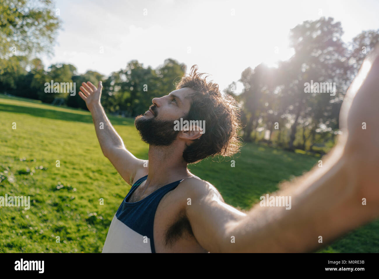Man enjoying the sunset in a park Stock Photo - Alamy