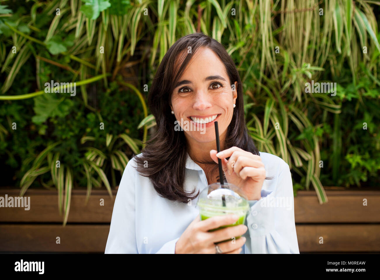 Women drinking green juice, detox, plastic cup Stock Photo - Alamy