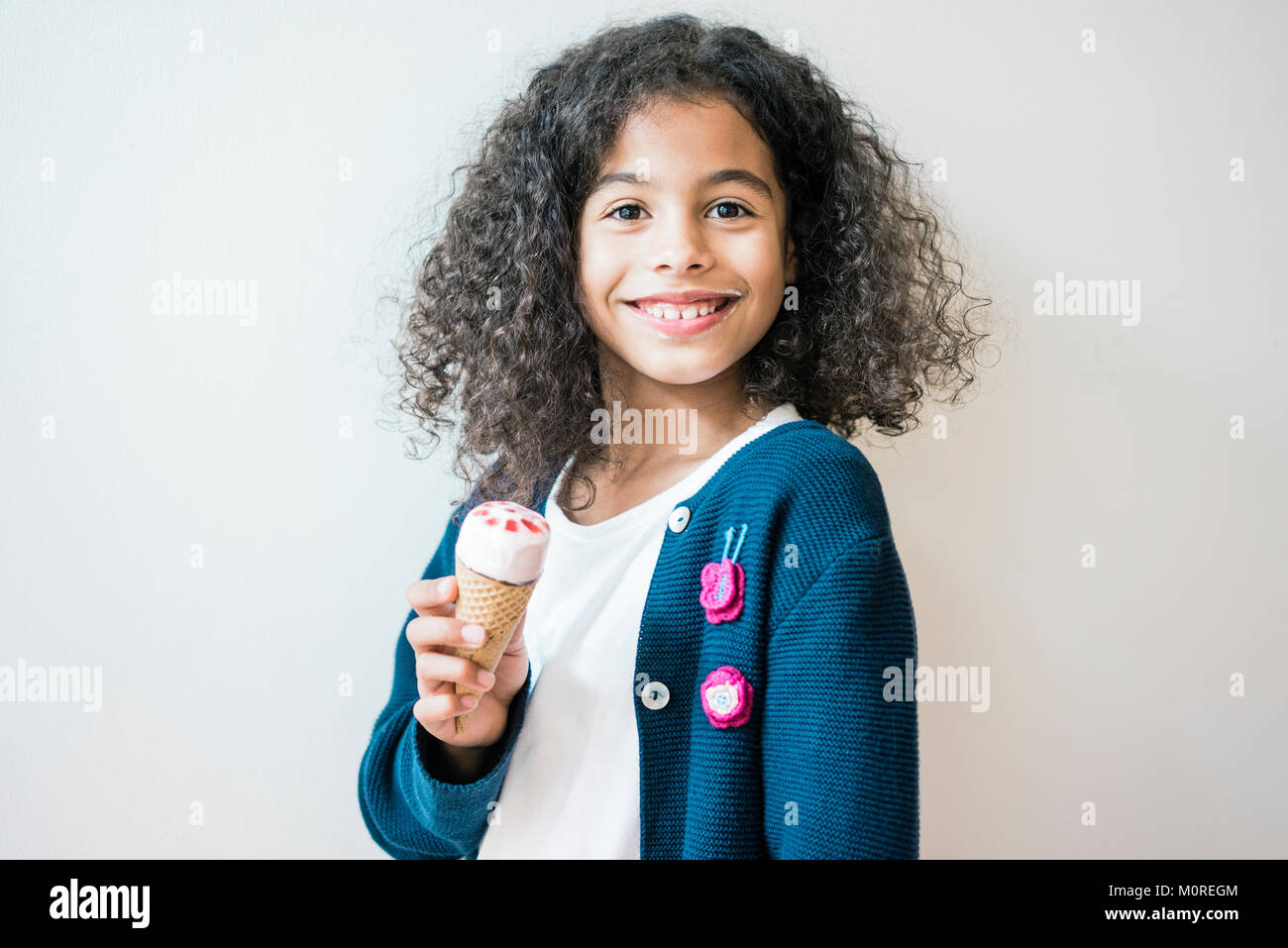 Cheeky little girl smiling at camera, eating ice cream Stock Photo - Alamy