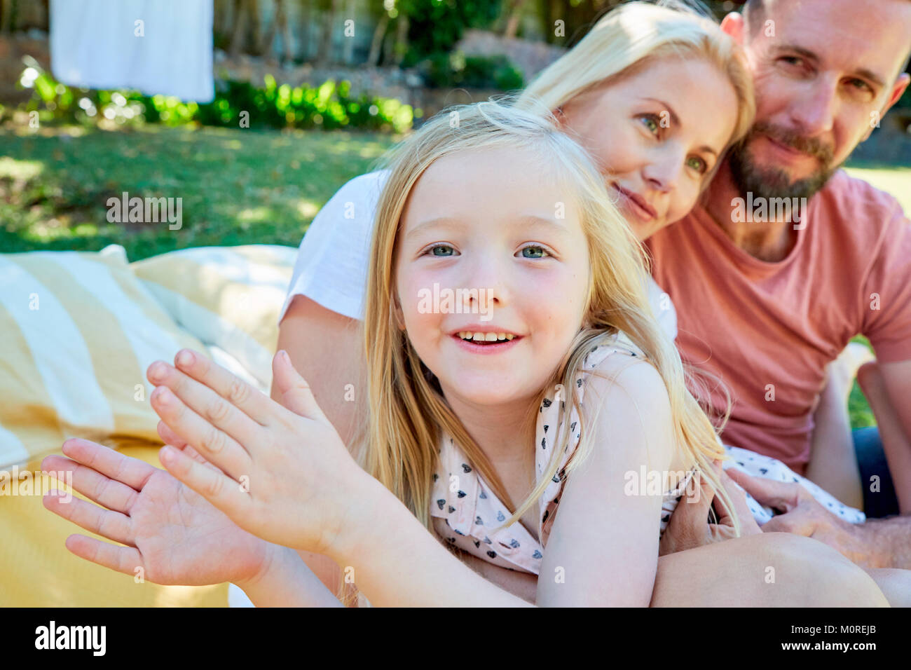 Portrait of happy girl with her parents in garden Stock Photo - Alamy